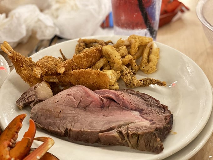 The prime rib shares plate space with golden fried seafood, proving that Boston Lobster Feast respects the classic surf and turf tradition.