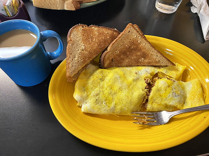 Breakfast meets lunch in this glorious affair—an omelet cozying up to toast on a fiesta-colored plate that brightens even Monday mornings.