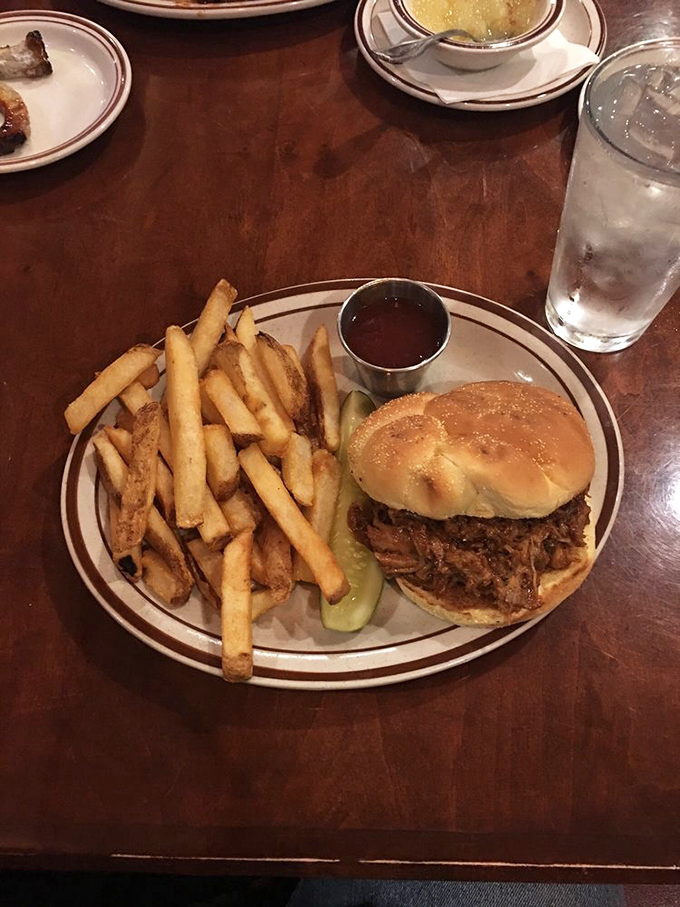 The pulled pork sandwich: where barbecue meets architectural perfection. Those hand-cut fries aren't just sides&mdash;they're supporting actors deserving their own award.