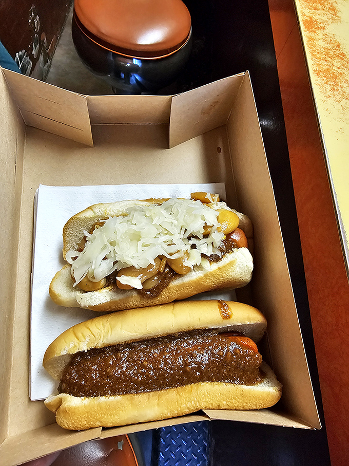 The famous Reuben dog shares box space with its chili-topped cousin. This isn't just lunch—it's a Pennsylvania pilgrimage in cardboard form.