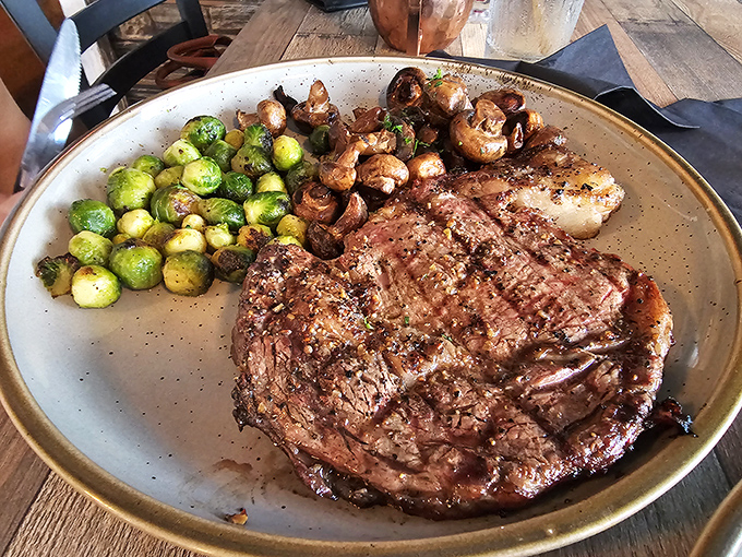 The star of the show: a perfectly seared ribeye flanked by Brussels sprouts and mushrooms. This isn't a meal; it's a celebration.