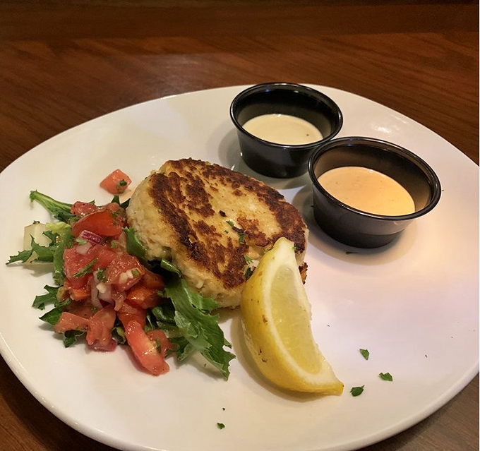 This crab cake isn't just golden&mdash;it's the Fort Knox of seafood starters. Two dipping sauces because important decisions shouldn't be forced upon you.