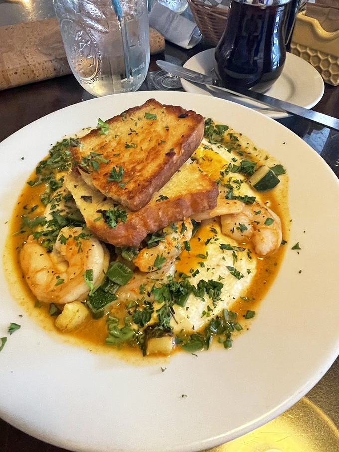 Shrimp and grits elevated to an art form, where seafood swims in a savory sauce that makes you question why you'd ever eat anything else before noon.