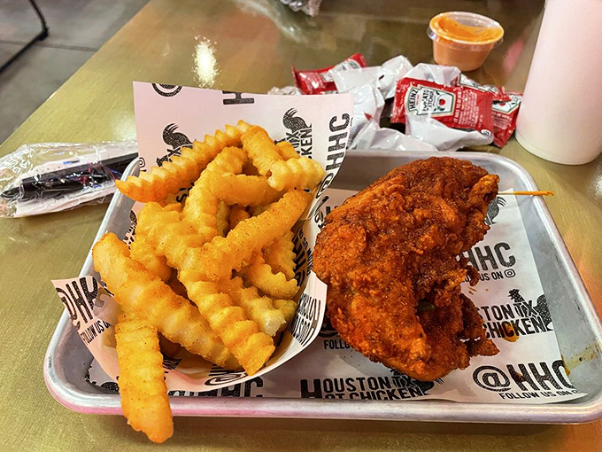 A study in contrasts: crispy, flame-colored chicken alongside golden waffle fries &ndash; a plate that's both beautiful and slightly terrifying.
