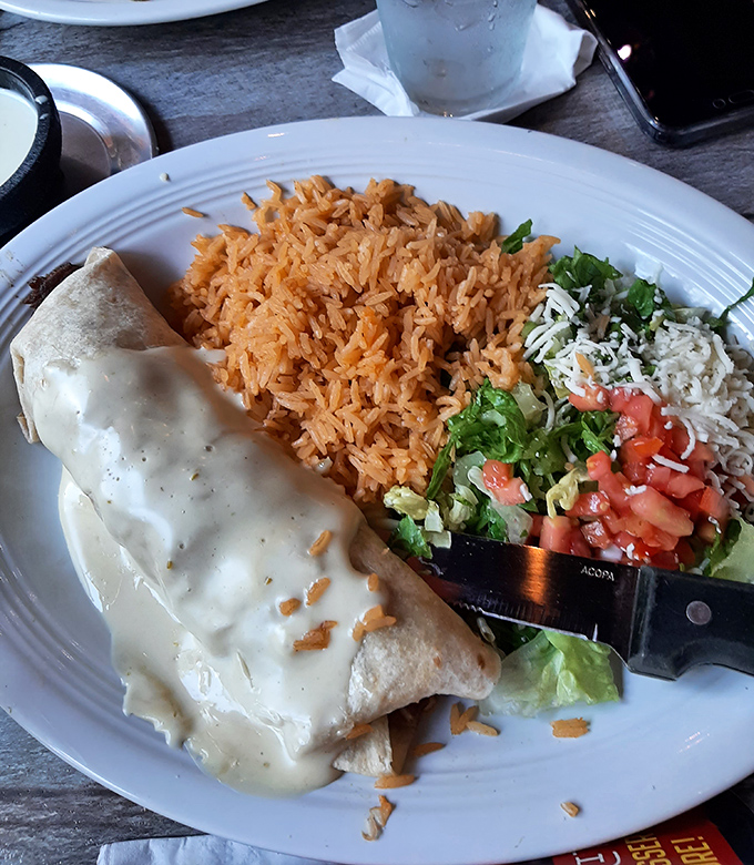 This isn't just a burrito – it's a commitment. Smothered in queso and served with perfectly seasoned rice, it's the comfort food you didn't know you needed.