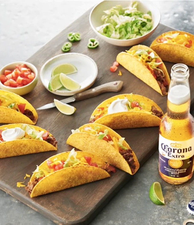 Tacos lined up like eager contestants in a beauty pageant, each one dressed to impress with fresh toppings and a Corona standing by for moral support.