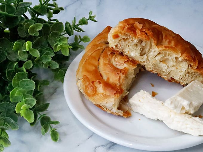 Tiropita that flakes with such dramatic enthusiasm, it deserves its own Greek tragedy. The cheese filling whispers "one more bite" with Mediterranean authority.