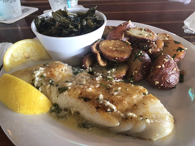 The chef's canvas in white. Perfectly seared fish bathed in garlic butter alongside roasted potatoes and collard greens&mdash;a Southern trinity of deliciousness.