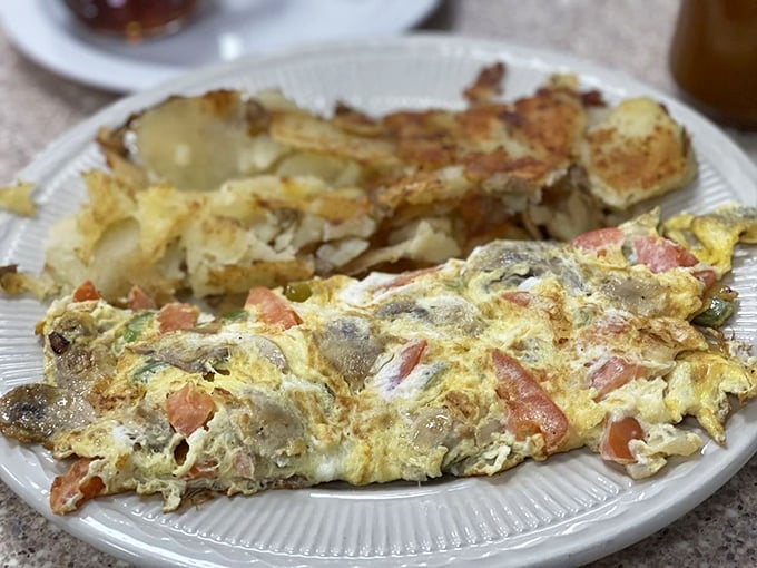 This isn't just any omelet&mdash;it's a vegetable sanctuary wrapped in perfectly cooked eggs. The hash browns deserve their own fan club.