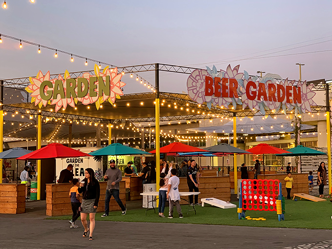 The Beer Garden glows at dusk, where giant Connect Four and string lights transform shopping breaks into mini-vacations.
