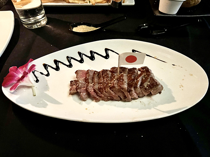Wagyu beef sliced with surgical precision, complete with a tiny Japanese flag. It's like meat origami&mdash;an art form that happens to be delicious.