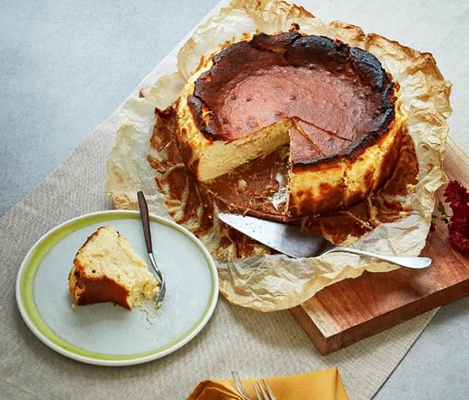 Basque cheesecake stands proud like a rustic monument to dairy perfection. That burnished top isn't a mistake&mdash;it's the signature that makes this dessert legendary.