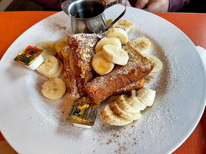 The Elvis would approve: French toast adorned with fresh bananas, powdered sugar, and what appears to be a splash of cinnamon&mdash;fit for The King himself.