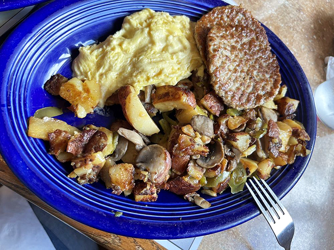 Breakfast perfection on a blue plate—where scrambled eggs meet home fries in a morning romance that's been going strong for generations.