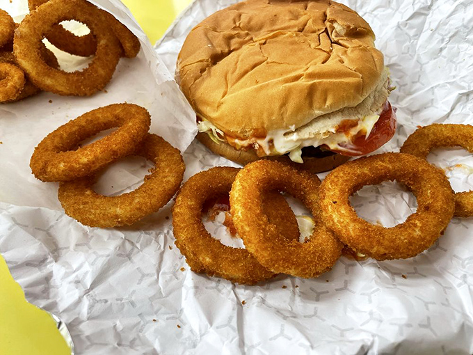 Golden-fried onion rings surround a classic cheeseburger like delicious life preservers in a sea of flavor. Dive in!