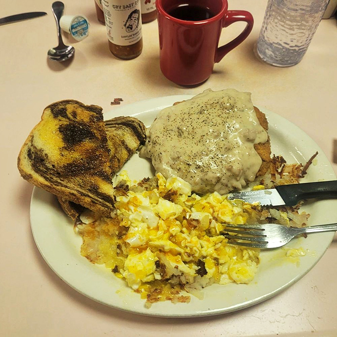 The sacred trinity of diner perfection: golden-crisp chicken fried steak, pepper-flecked country gravy, and eggs with sunshine-yellow yolks.