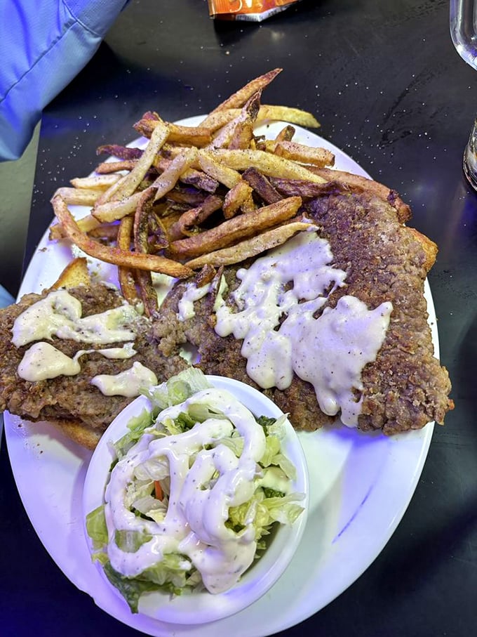 The holy trinity of Texas dining: perfectly crusted chicken fried steak, hand-cut fries, and a side salad that's technically a vegetable, right?