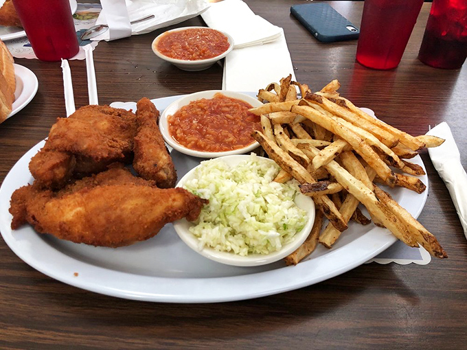 The holy trinity of comfort food: crispy chicken, creamy coleslaw, and that distinctive hot sauce that's worth the drive alone.