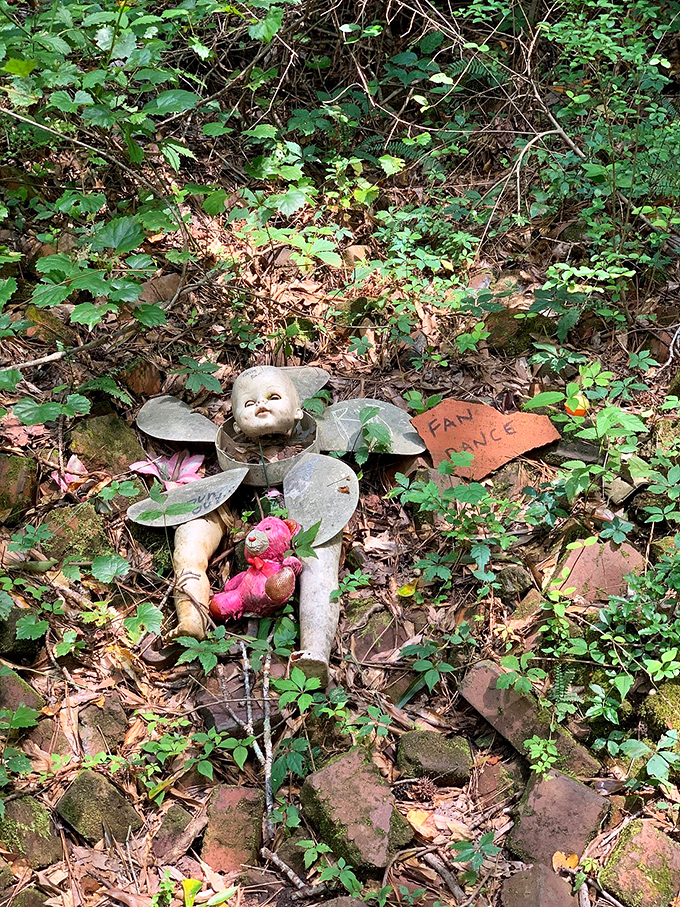 A fallen angel or nature sprite? Discarded doll parts and metal scraps create an unexpected fairy-like figure among the leaves.