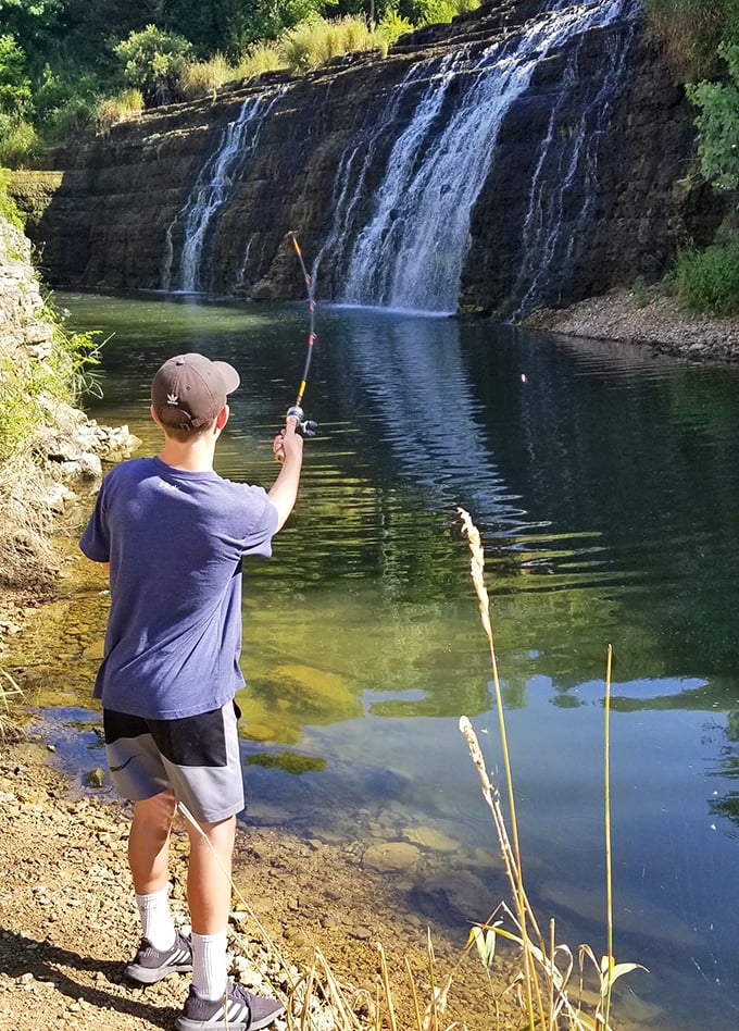 Gone fishing takes on new meaning when your backdrop is a limestone waterfall. This young angler might catch dinner, but he's already caught something priceless.