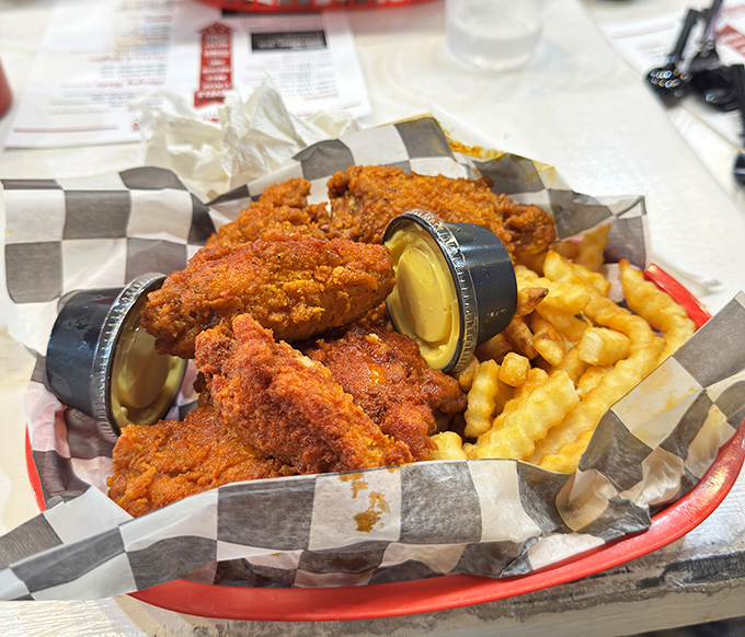 Crispy, cayenne-kissed tenders nestled beside crinkle-cut fries, with dipping sauces standing by for emergency cool-down operations.