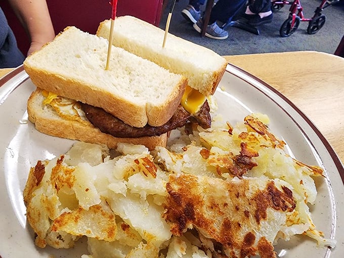 The breakfast sandwich sits proudly alongside crispy home fries that look like they've been gossiping with butter and salt in all the right ways.
