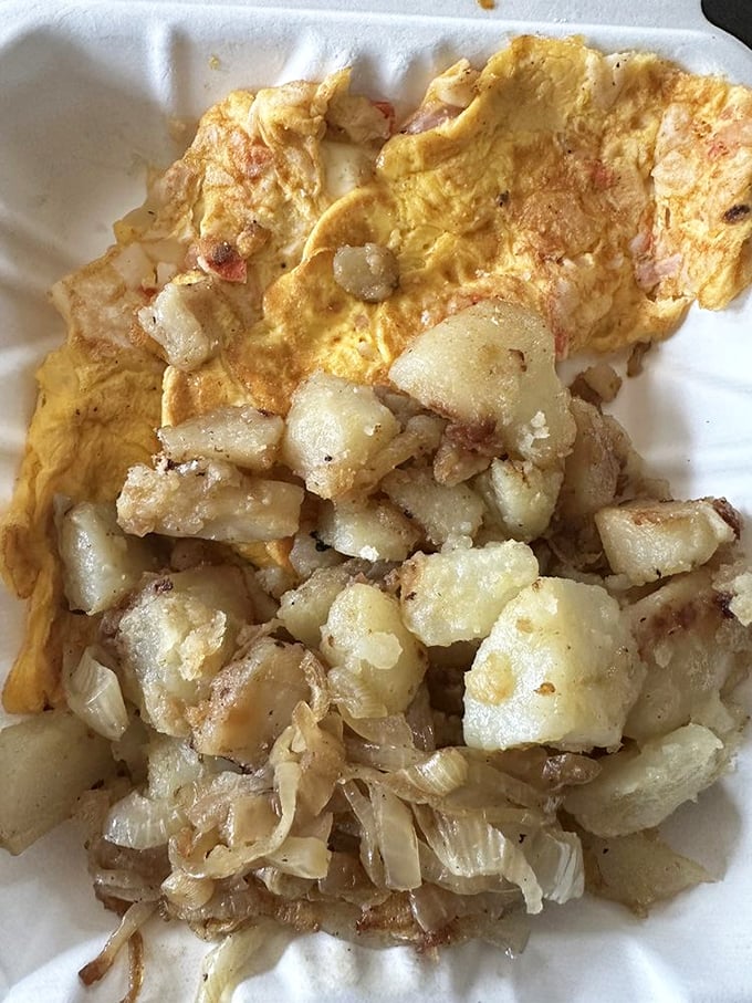 Home fries with that ideal crisp-tender balance, nestled beside an omelet that doesn't need fancy French techniques to deliver pure satisfaction.