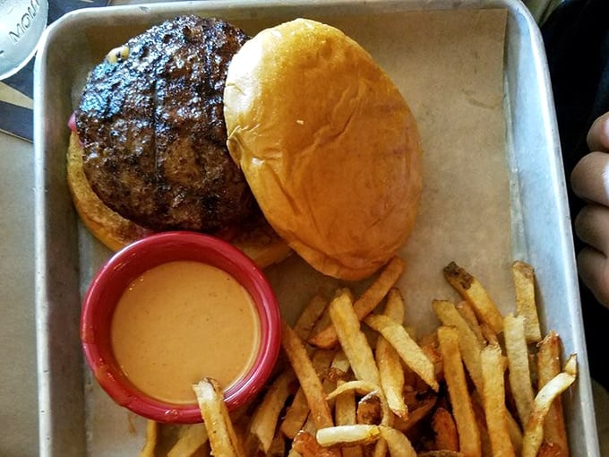 The Woodchip Burger arrives like a delicious geometry problem: round bun, square patty, triangular fries, and a circular cup of sauce that solves everything.