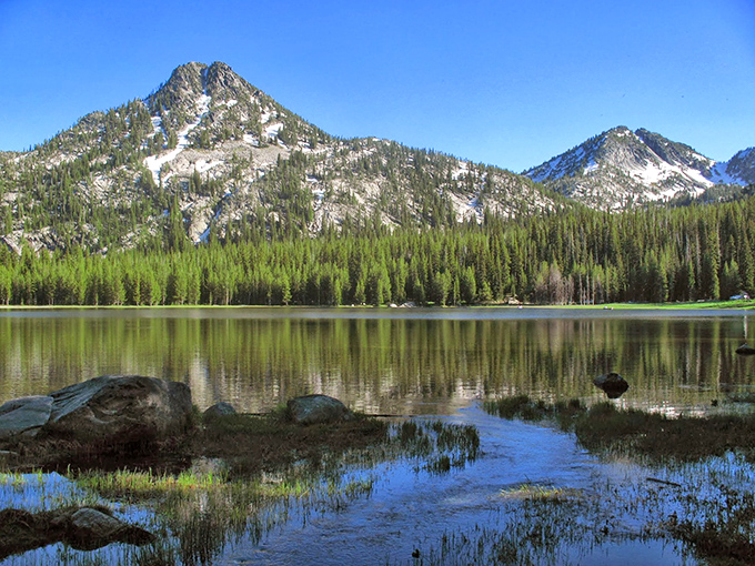 Mirror-like waters reflect the majesty of nearby mountains, offering meditation-worthy views that cost nothing but the time to appreciate them.