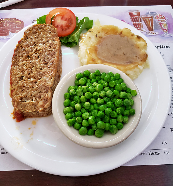 Some meals are so perfectly composed they deserve their own oil painting. This meatloaf plate with its vibrant green peas could hang in the Museum of Comfort Food.