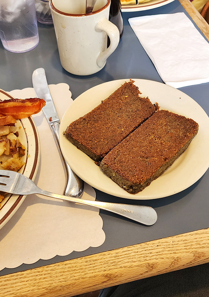 The legendary meatloaf arrives like two slabs of comfort food perfection – dense, moist, and with that irresistible caramelized exterior.