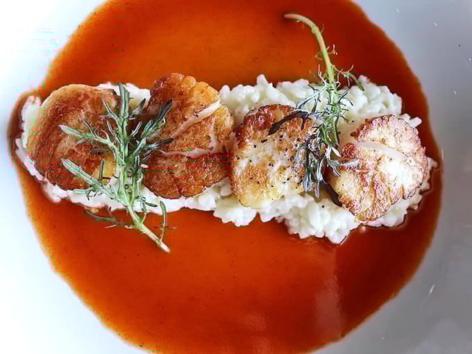 Scallops perched on risotto like royalty on a throne. The sauce isn't just poured&mdash;it's carefully introduced to the plate.