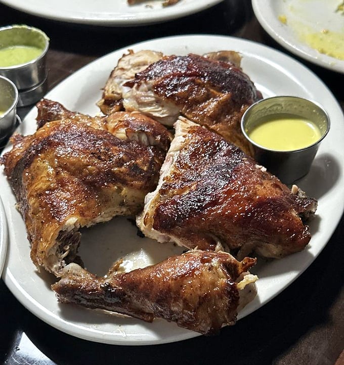 Pollo a la brasa &ndash; the star of the show. That mahogany skin, that juicy meat, those little metal cups of sauce that change everything.