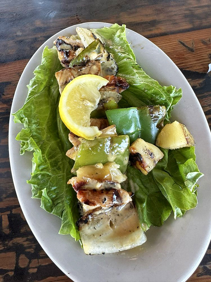 Nature's perfect food delivery system: the skewer. Grilled fish and vegetables arranged like edible jewelry on a bed of crisp lettuce.