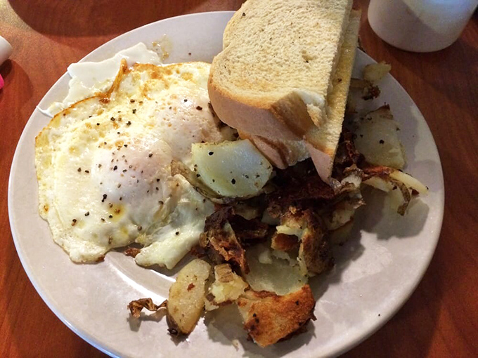 Breakfast alchemy at its finest—crispy home fries mingling with eggs and toast in a plate that screams "Good morning!" even if you're whispering "too loud."