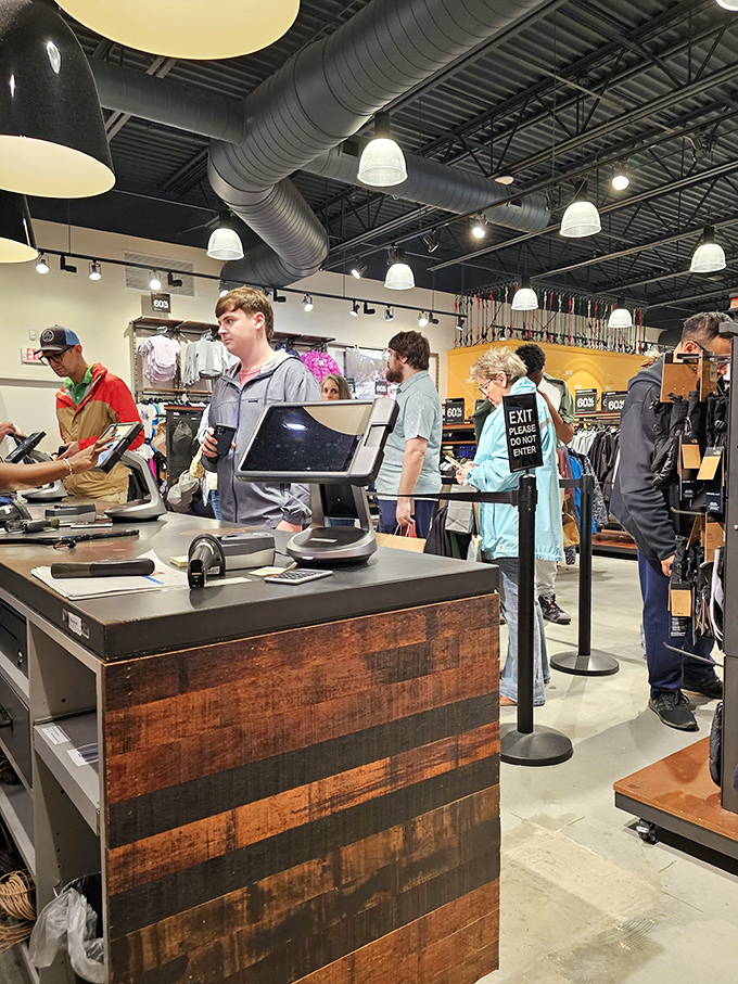 The checkout line dance: customers patiently waiting their turn while industrial-chic design elements create an atmosphere that's equal parts warehouse and boutique.
