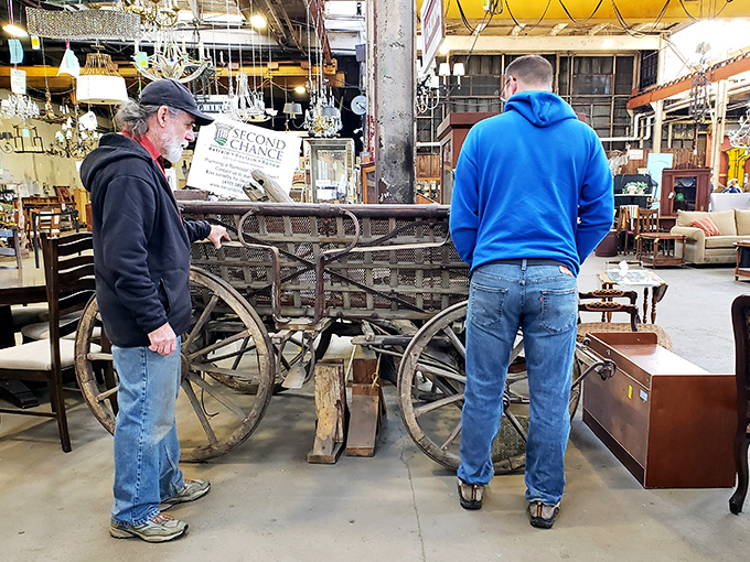 Treasure hunters examining an antique cart, contemplating whether it belongs in their garden or as the world's most interesting coffee table.