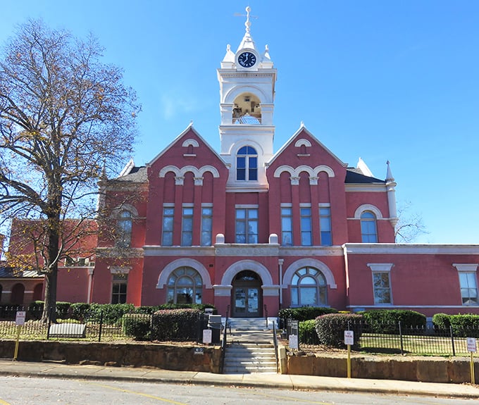 The historic red-brick courthouse in Gray stands proudly against the blue sky, its white clock tower keeping time for generations of Georgians.