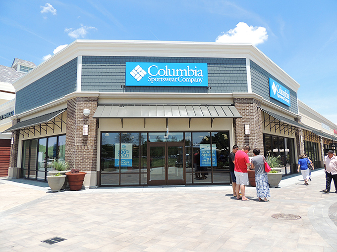 Columbia Sportswear's corner position makes it a beacon for outdoor enthusiasts seeking deals. The brick and stone fa&ccedil;ade adds a touch of permanence to fleeting fashion.