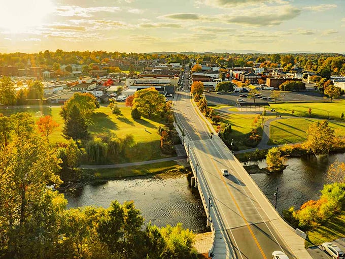Golden sunlight bathes Sperryville as the river flows under the bridge, welcoming you to this charming town nestled in nature.