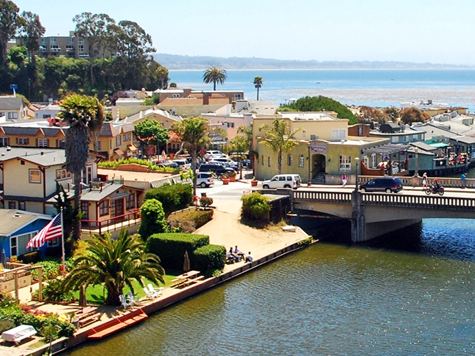 The gentle waters of Capitola's harbor reflect buildings that seem to be competing in a "most charming waterfront" contest.