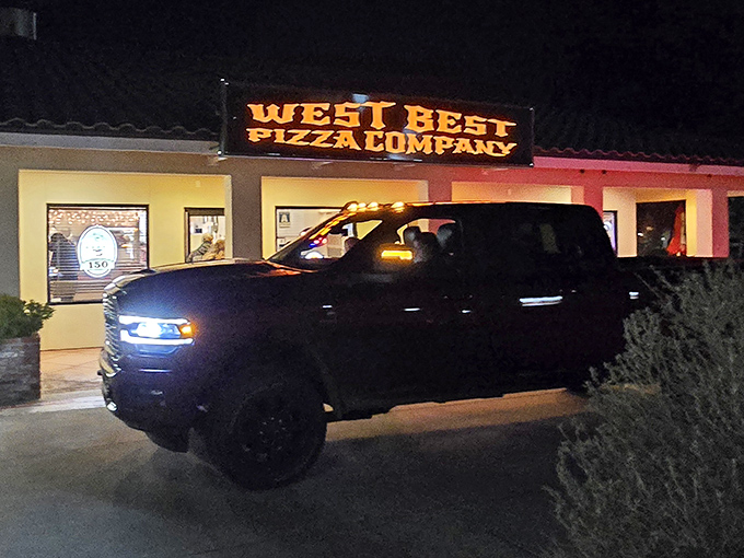 By night, this unassuming storefront transforms into a glowing pizza oasis for hungry desert dwellers.