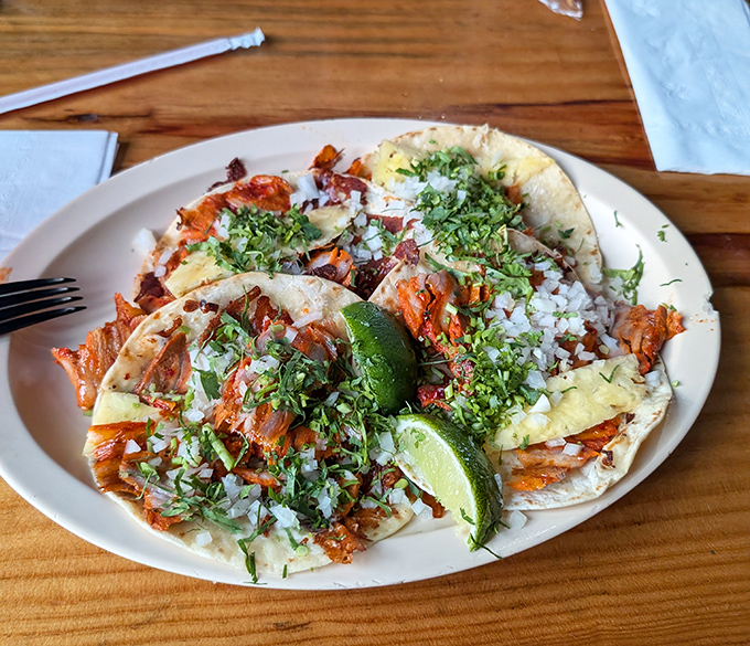 Taco perfection exists, and here's the evidence. Caramelized pork, fresh cilantro, and diced onion create a holy trinity of flavor.