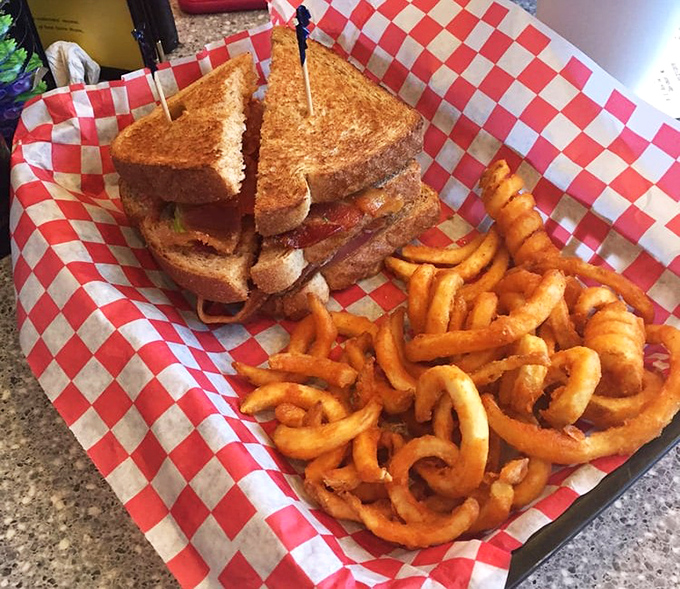 This isn't just a sandwich—it's architecture. The BLT towers with purpose while those curly fries perform delicious loops around your taste buds.