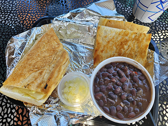 Black beans so rich they could buy beachfront property, paired with a sandwich pressed to crispy perfection&mdash;comfort food that speaks two languages fluently.