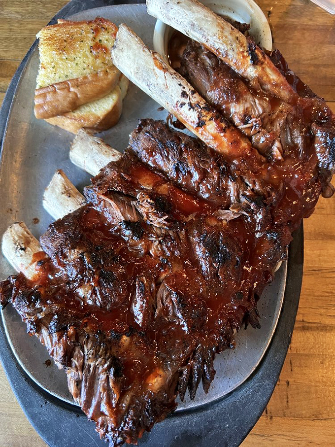 Sink your teeth into these tender, sauce-dripping beef ribs at Trabuco Oaks Steakhouse, served with a side of buttery toast.