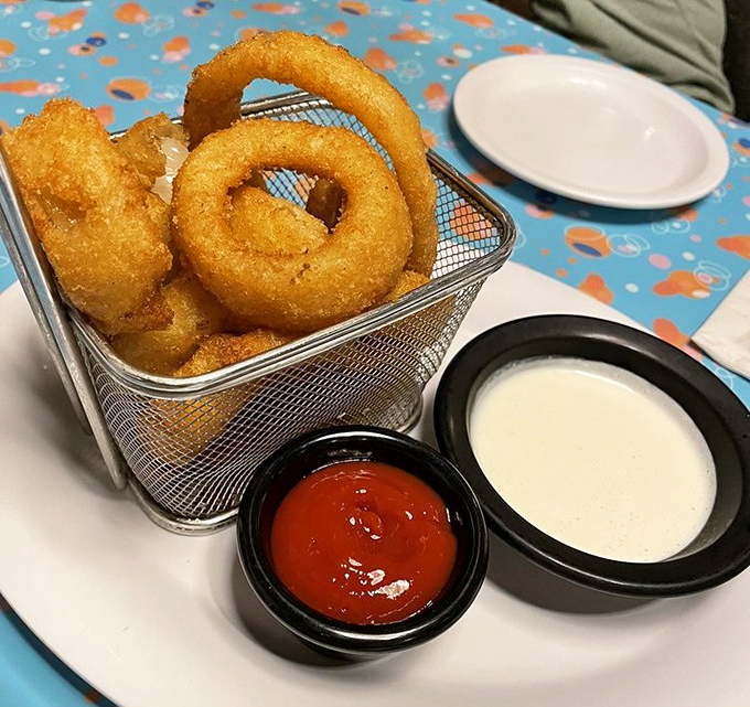 These aren't just onion rings—they're golden halos of happiness, served in a wire basket that screams "diner chic."