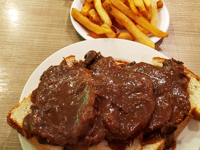 Open-faced meatloaf that doesn't hide behind pretense. When gravy cascades like this, you know you've found food that hugs you from the inside. 