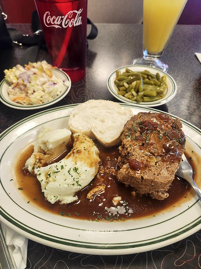 Green beans and coleslaw provide the supporting cast, but make no mistake—that meatloaf is the headliner deserving of its own marquee.