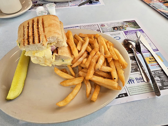 Breakfast sandwiches should be knighted for their service to humanity. This grilled masterpiece with golden fries proves simple food done right is culinary royalty. 